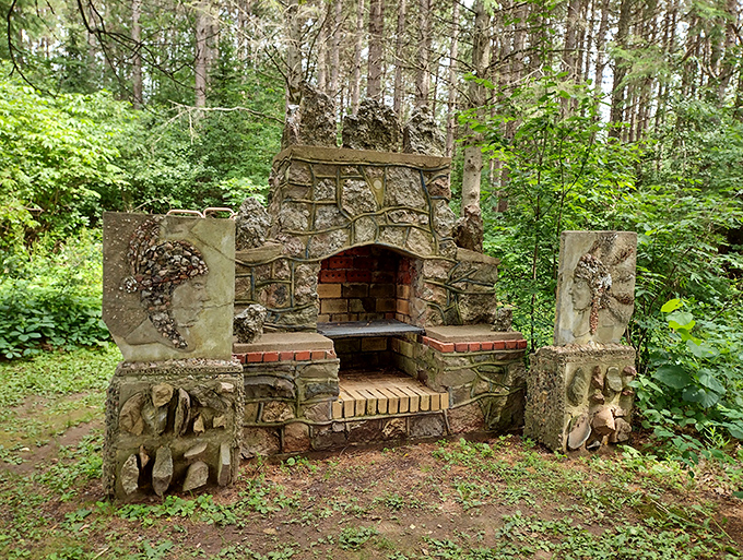 This artistic fireplace nestled among the trees combines function with folk art flair—imagine the stories shared around its concrete hearth!