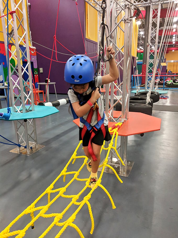 Beginner Ropes Challenge: First steps into aerial adventure, where determination meets harnesses in a dance of cautious bravery.