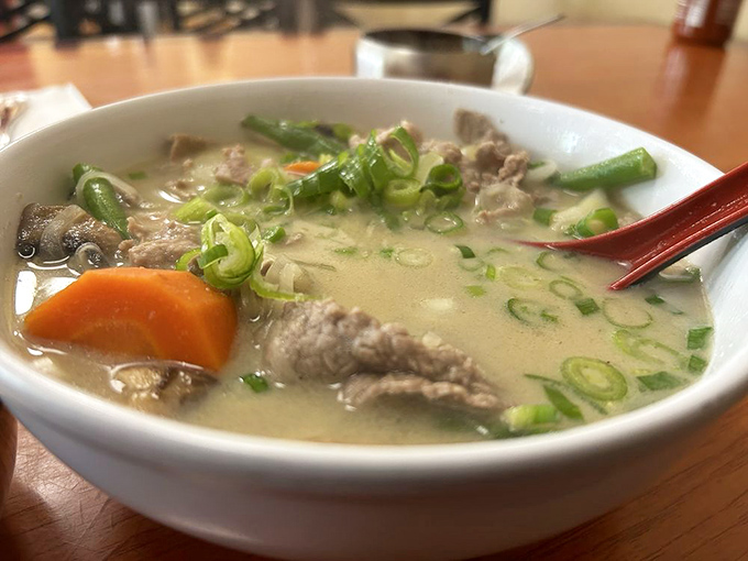 This fragrant bowl of green curry showcases tender beef, fresh vegetables, and aromatic herbs in a silky, flavorful broth.