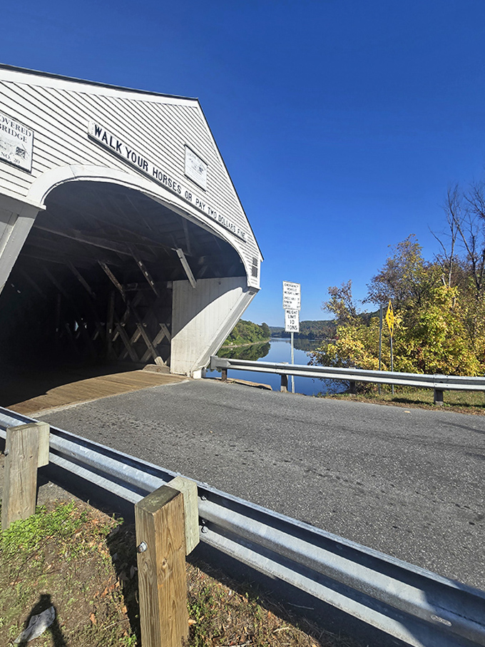 The iconic white entrance stands in stark contrast to the weathered wooden interior, welcoming travelers between New Hampshire and Vermont.