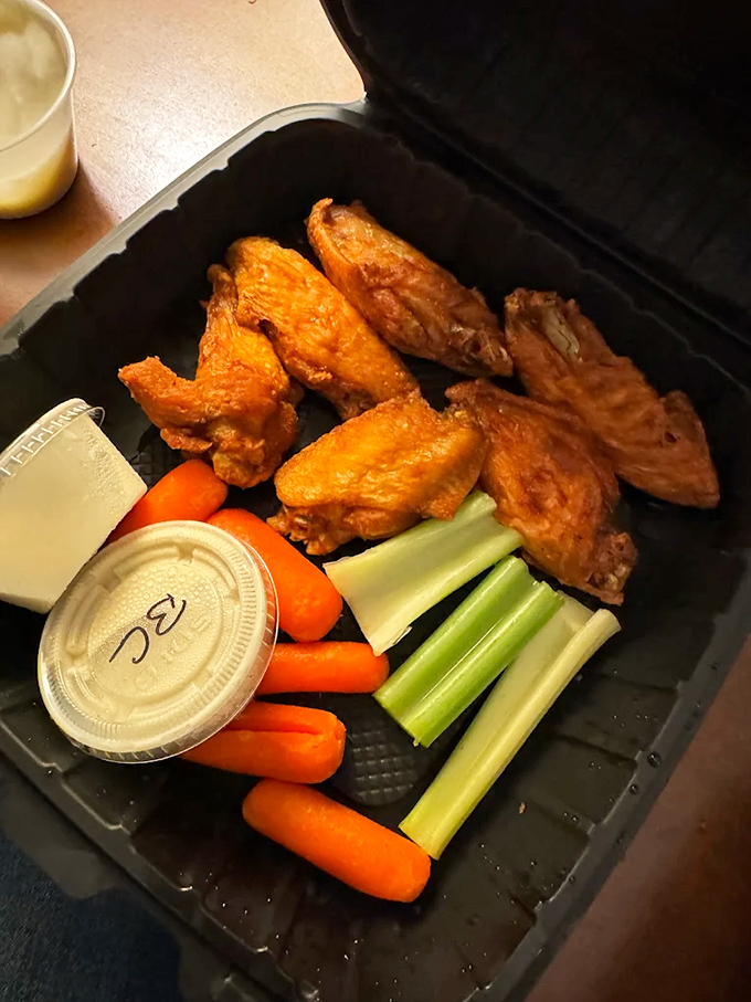 Perfectly crispy wings with fresh veggies and dipping sauce make for the ultimate pub food experience.