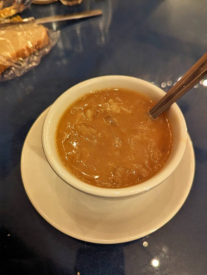 A steaming bowl of cabbage soup, its clear amber broth holding the essence of slow-cooked vegetables and family tradition.