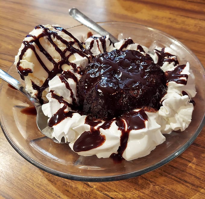 The chocolate lava cake erupts with warm, gooey goodness, surrounded by whipped cream for those who somehow saved room.