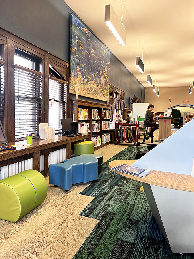Modern furnishings complement historical architecture in this reading nook, where natural light streams in through tall windows.