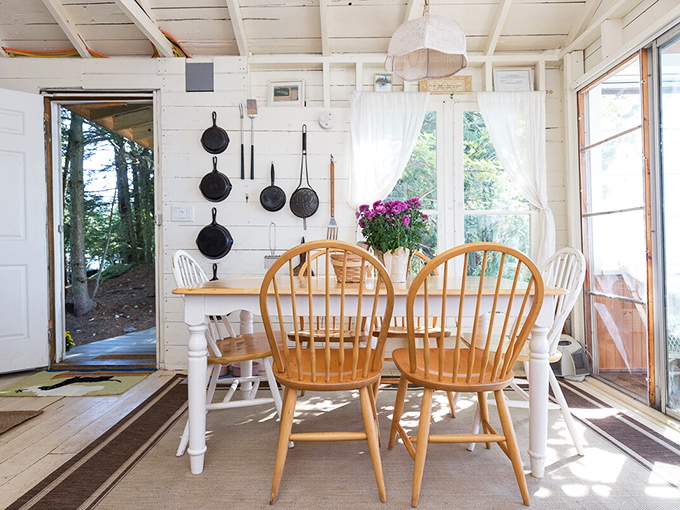 Mismatched chairs around a simple wooden table &ndash; because meals taste better when seasoned with lake breezes and laughter.