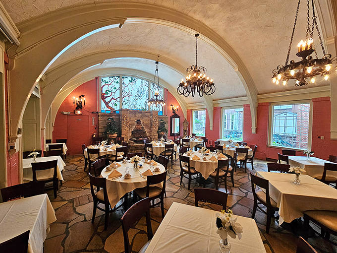 Arched ceilings and coral walls create an intimate atmosphere in this dining area, where tables are generously spaced for private conversations and lingering meals.