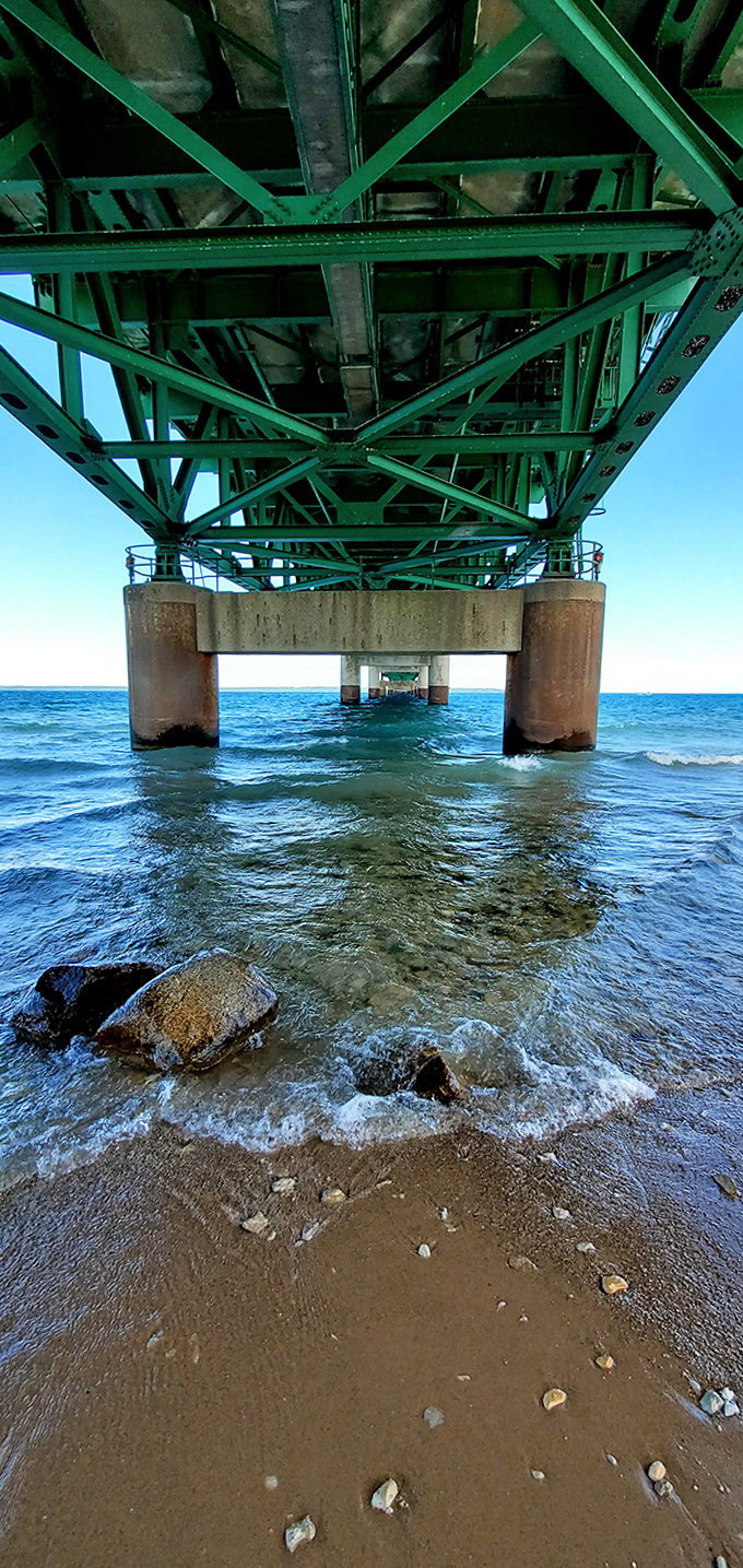 Beneath the massive steel framework, waves lap against concrete pillars that have withstood decades of currents, storms, and shifting ice floes.