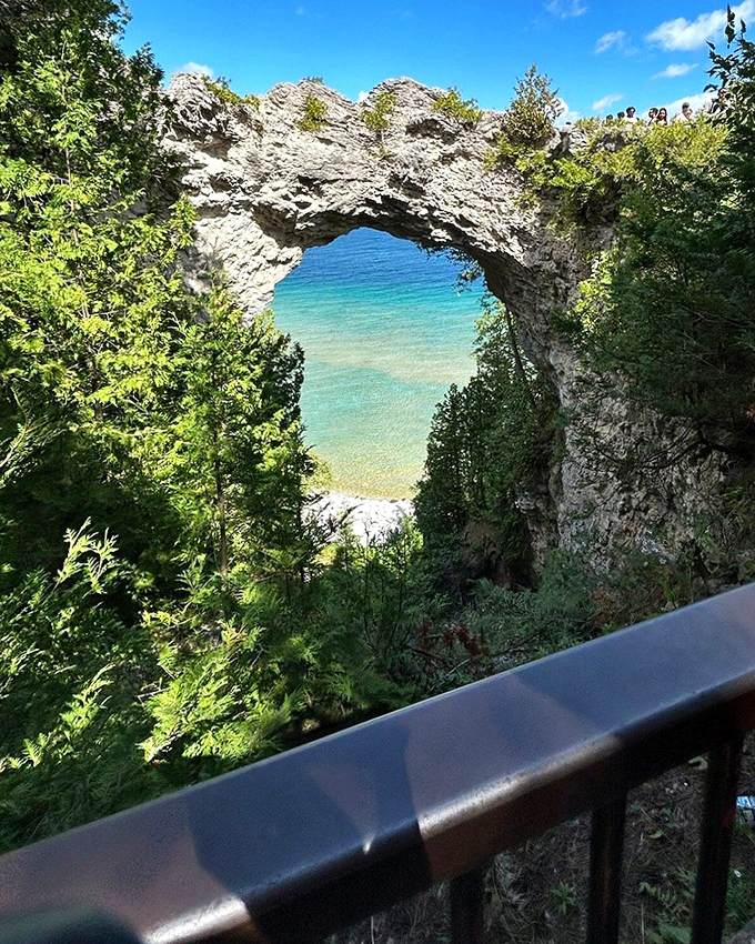 Sunlight plays across the limestone arch, highlighting 350 million years of geological patience that created this perfect natural doorway.