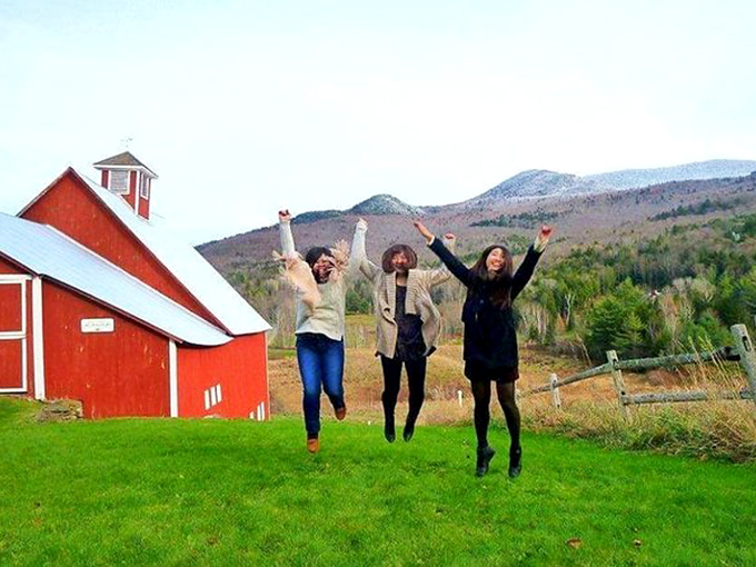 Pure joy captured mid-jump against a Vermont backdrop, because sometimes the best way to appreciate beauty is to literally leap into it with friends.