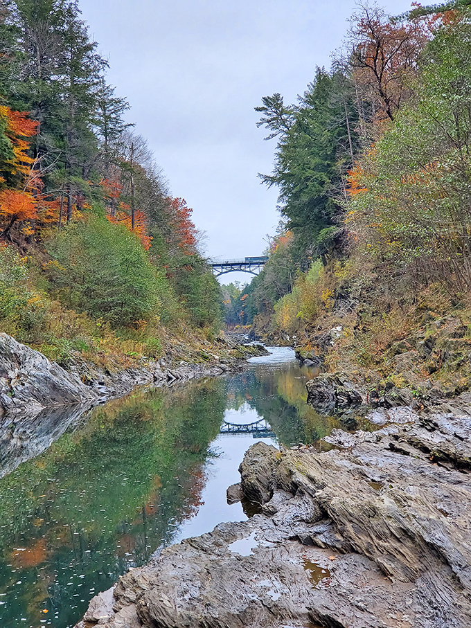 Fall transforms the gorge into a painter's palette of warm colors, reflecting in the calm waters below like nature's own double-feature.