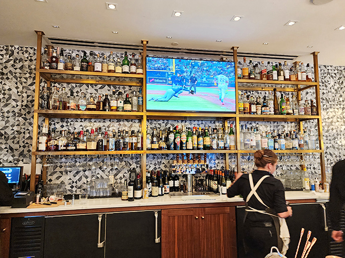 Bottles stand at attention like soldiers of satisfaction behind this impressive bar, where mixologists craft liquid art with precision.