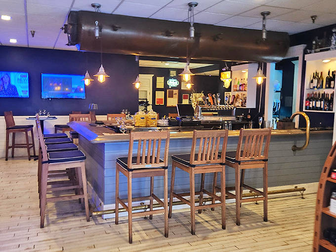 The bar area invites lingering – warm wood tones and industrial lighting create the perfect perch for watching bartenders work their magic.
