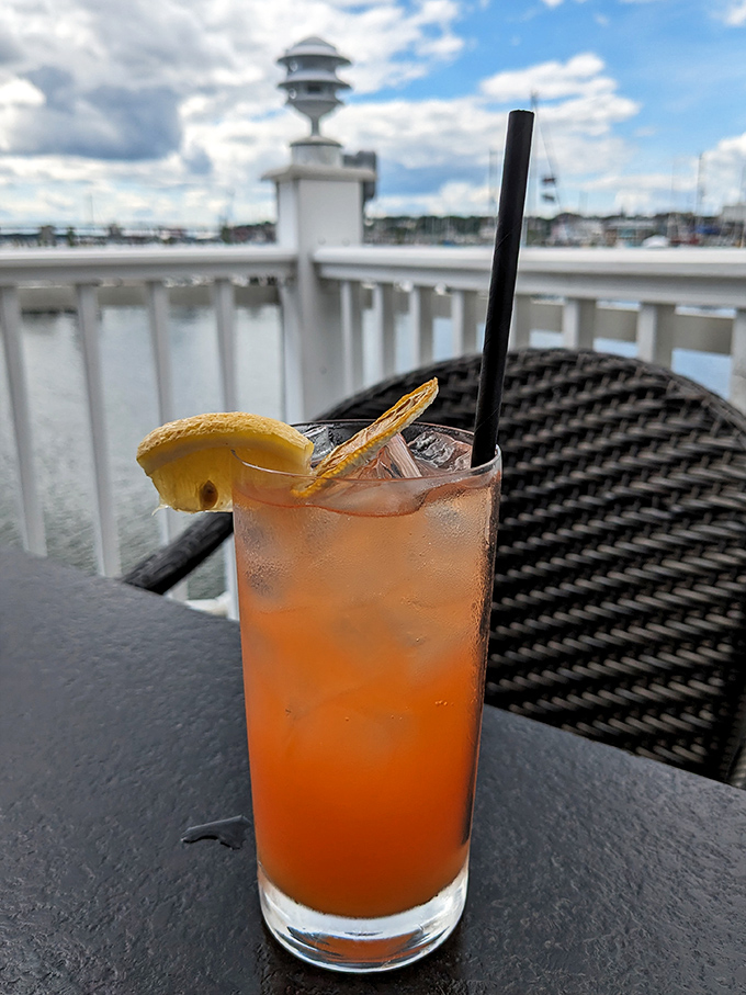 Sunset-colored cocktail with harbor views &ndash; vacation in a glass. The condensation isn't sweating; it's applauding your excellent taste.