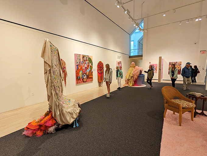 Visitors wander through a thoughtfully curated exhibition space where textile art and contemporary paintings create visual conversations.