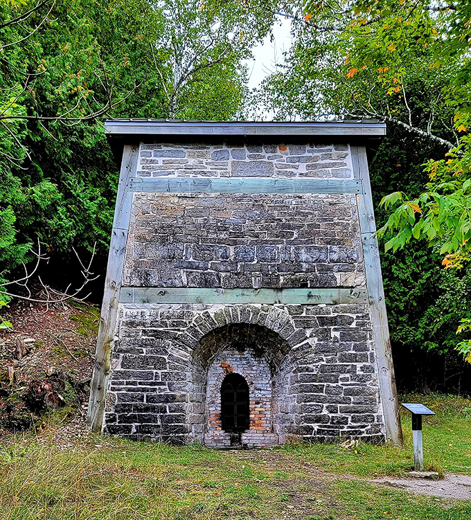 This stone structure once housed the fiery heart of iron production, its arched opening now a window to industrial history.