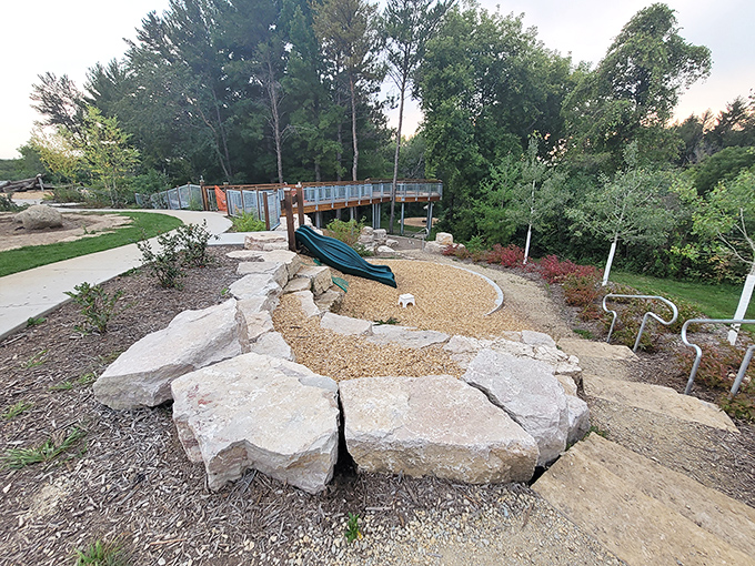 Natural stone borders frame this slide area, where gravity becomes every child's favorite science experiment.