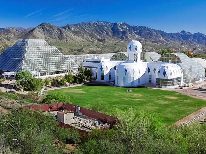 Biosphere 2 rises from the desert like a futuristic crystal palace, its gleaming geodesic domes housing complete ecosystems under glass.