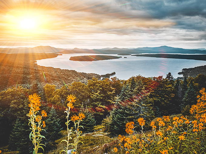 Rangeley Lakes Scenic Byway offers sunset vistas across mountains and lakes that showcase Maine's natural splendor in golden light.