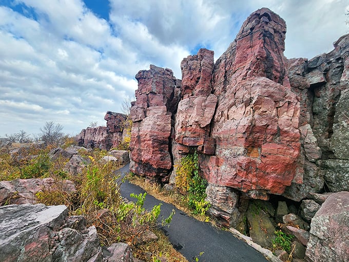 Pipestone's dramatic red rock formations create a striking contrast against the green prairie, their weathered faces sculpted by centuries of wind and rain.