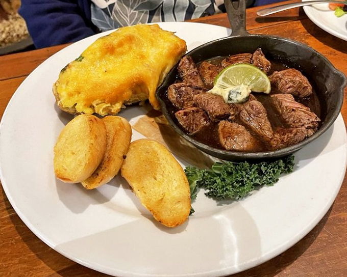 Beef tips served in a cast iron skillet&mdash;because proper steak deserves proper cookware. That cornbread looks like it could start a religion.