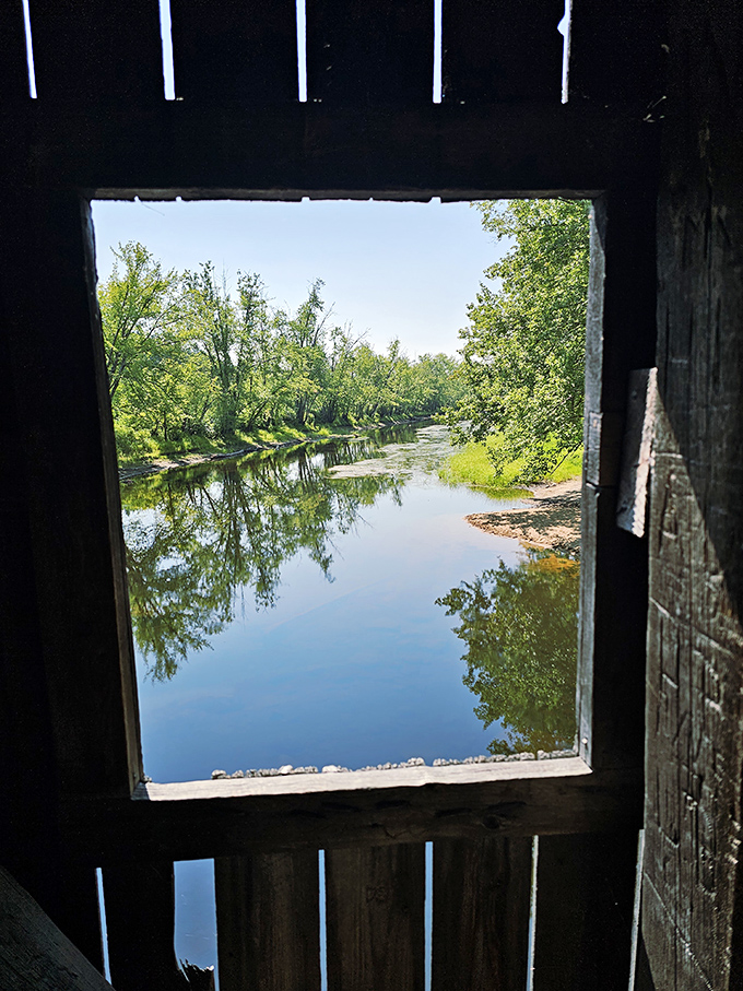 Autumn transforms Hemlock Bridge into a gateway to fall splendor, with foliage creating a fiery contrast to weathered wooden planks.