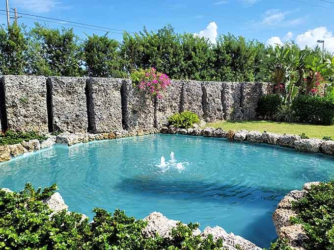 Even the pond is carved from coral, holding water in stone that one person shaped into a functional, beautiful feature.