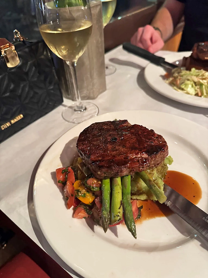 Filet mignon perched atop fresh vegetables like a crown jewel, proving that sometimes the classics become classic for very good reasons indeed.