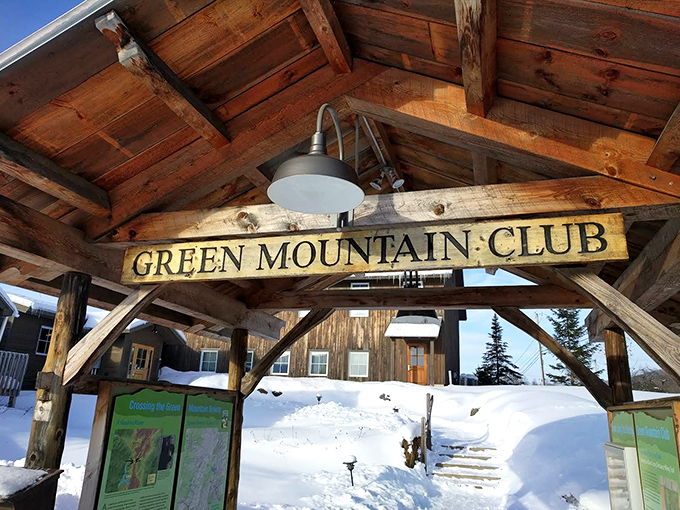 The Green Mountain Club sign stands sentinel in winter snow, marking the gateway to adventures that have been making calves sore and hearts full since 1910.