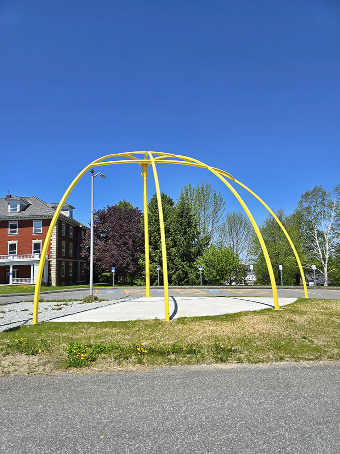 The Sun installation glows with artistic interpretation, its wooden rays reaching outward like a cosmic flower blooming in Maine soil.
