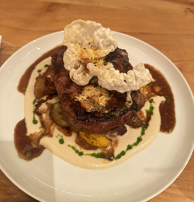 A ribeye steak that demonstrates the kitchen's mastery of temperature and timing, resting on a bed of seasonal accompaniments.