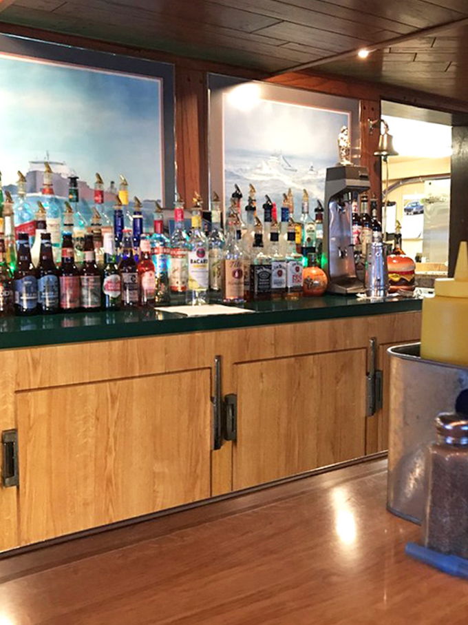 The bar area showcases an impressive selection of spirits, where nautical dreams and burger-induced happiness flow in equal measure.