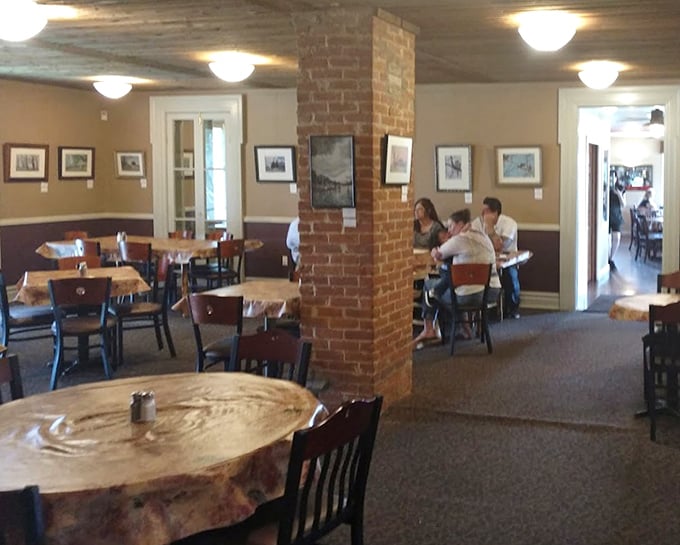 Exposed brick columns and cozy seating create dining spaces that feel private yet connected to the restaurant's vibrant energy.