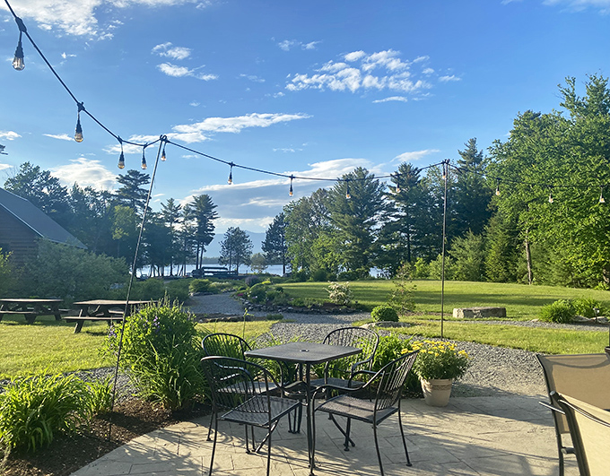 The outdoor seating area where string lights twinkle above tables as the lake whispers nearby &ndash; Mother Nature's dining room with better service.