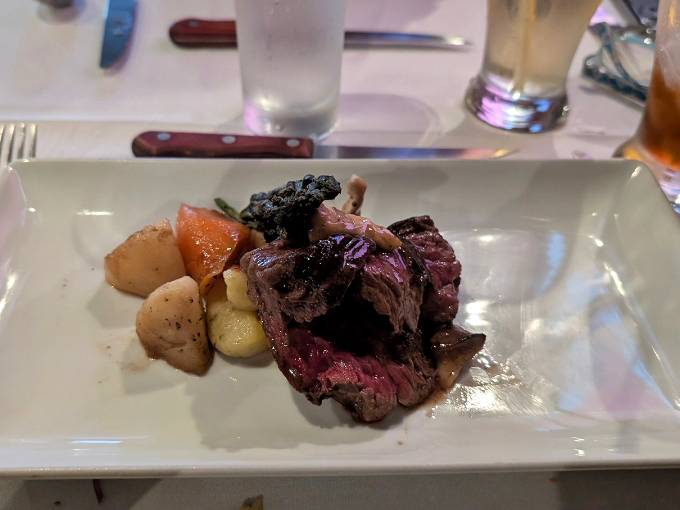 A perfectly cooked steak, sliced to reveal a rosy interior, accompanied by seasonal vegetables and a dollop of something creamy and indulgent.