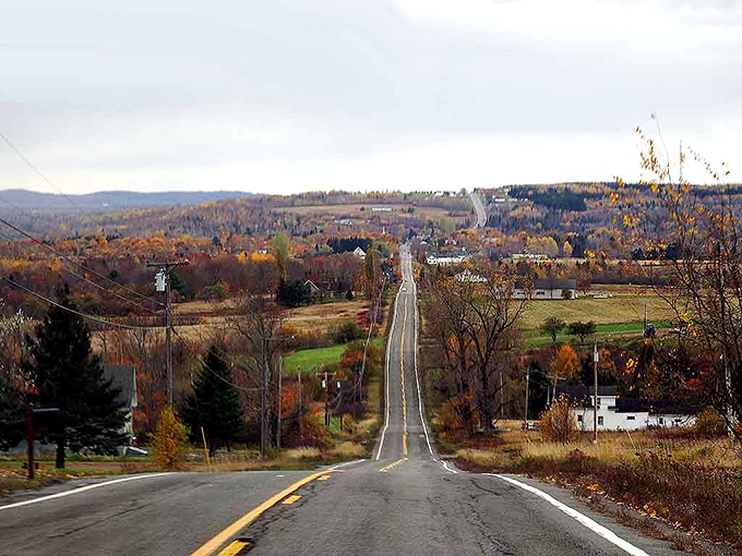 The winding roads of Patten cut through spectacular fall foliage, with mountains rising in the misty distance.