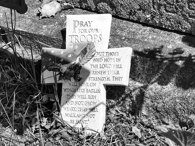 This simple stone cross bears a powerful message of faith and remembrance for fallen service members, a quiet reminder of sacrifice.