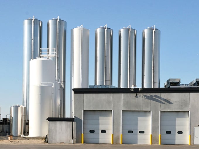 Gleaming silver silos stand like sentinels, guarding the precious milk that will become tomorrow's string cheese.
