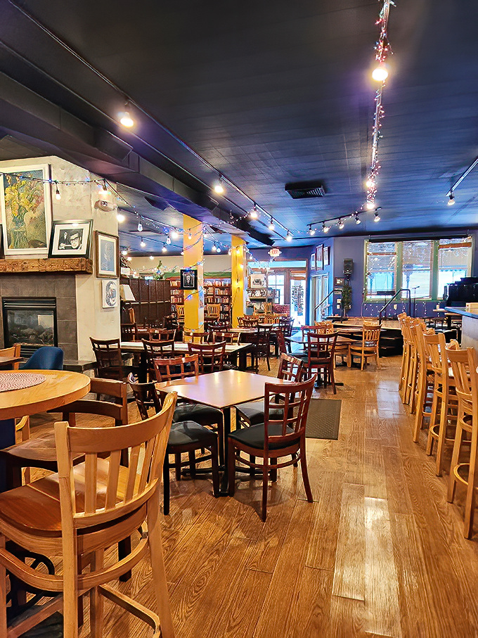 Enjoy this cozy caf&eacute; interior glowing with string lights, wooden tables, and an inviting, laid-back atmosphere.