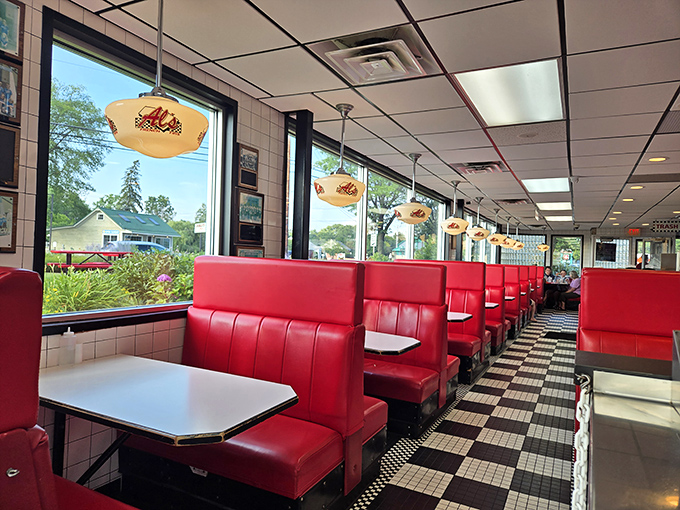 Sunlight streams through windows onto cherry-red booths, creating the perfect backdrop for memories waiting to be made.