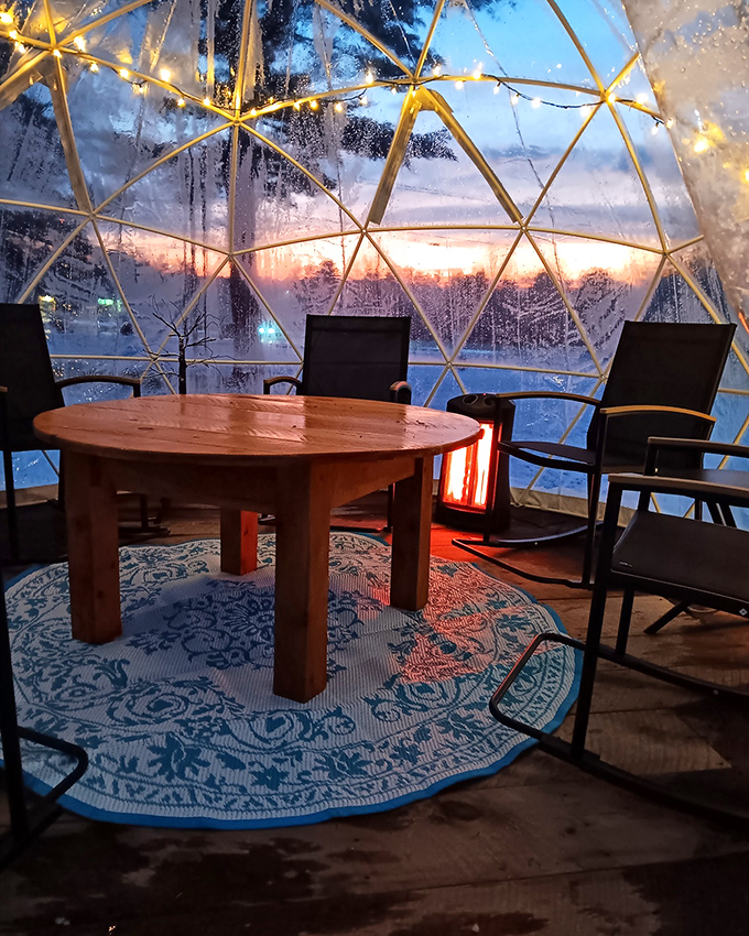 Inside the dome, string lights create an atmosphere that five-star restaurants would envy, while winter's beauty unfolds just beyond the transparent walls.