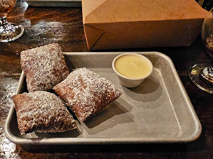 Warm, sugar-dusted beignets with dipping sauce offer a sweet finale that somehow manages to find room even after a substantial burger feast.
