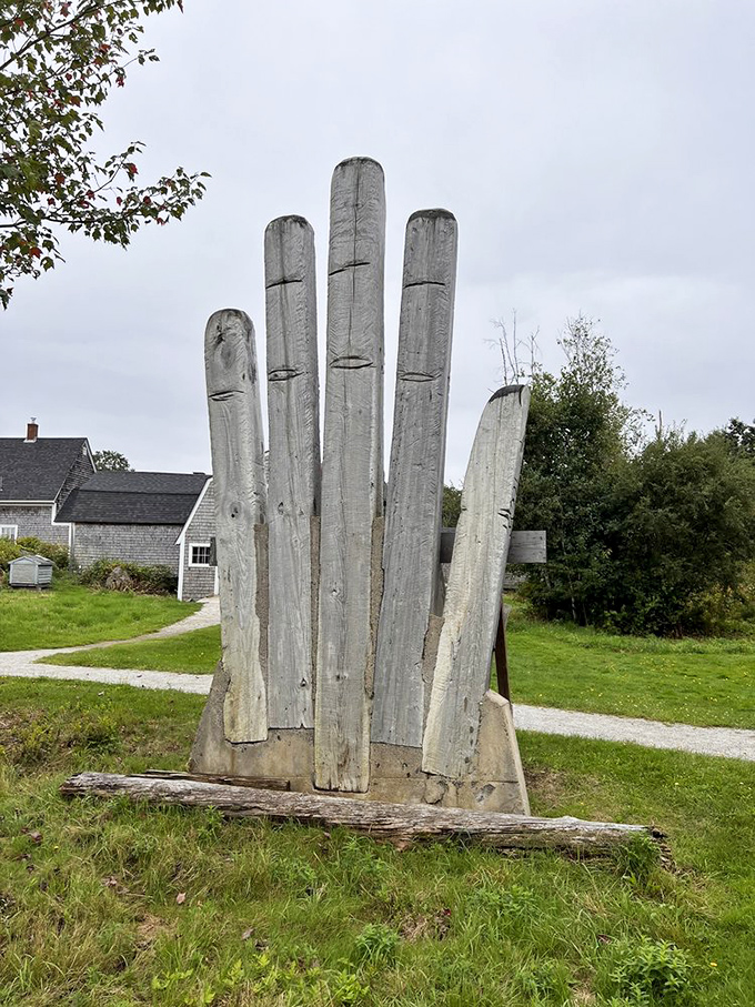 A giant wooden hand reaches skyward, its weathered fingers like ancient trees stretching toward the clouds in silent celebration.