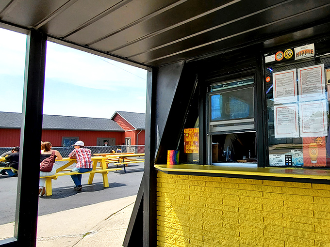 The ordering window, framed in black with a sunny yellow counter, serves as the gateway to flavor town at this unique Michigan eatery.