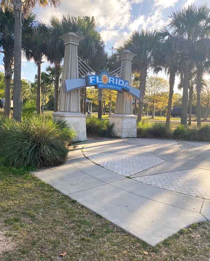 Palm trees cluster around the archway like they're posing for their own postcard, providing that essential tropical backdrop everyone craves.