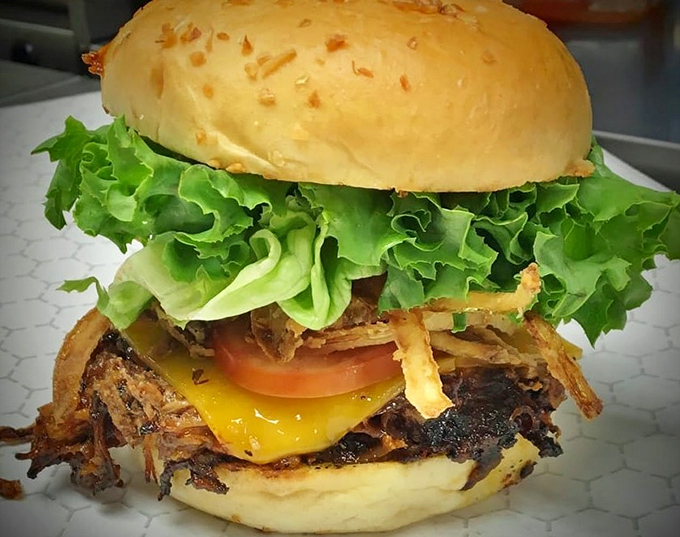 This towering burger creation showcases The Toasted Pickle's commitment to hearty portions and picture-perfect presentation.