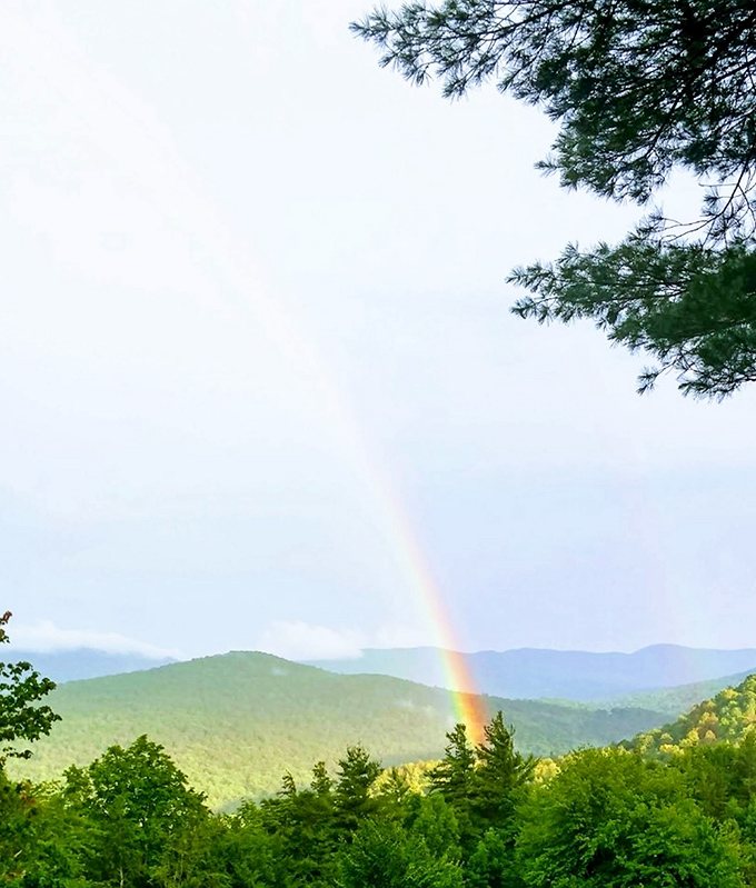 Nature's own light show – a perfect rainbow arcs across the valley, turning an already beautiful view into something truly magical.