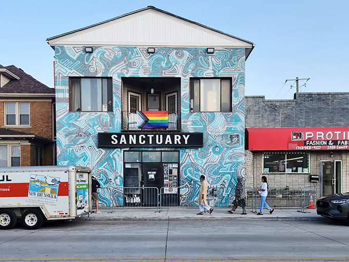Sanctuary Detroit's striking blue mural and rainbow flag announce its mission as a welcoming space in Hamtramck's tapestry of inclusive community gathering places.