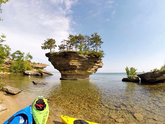 Beached kayaks mark the gathering spot for adventurers taking a break to swim, explore, or simply marvel at nature's sculptural achievement.