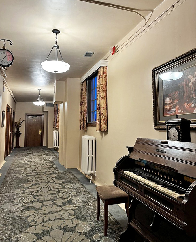The top floor corridor, with its period lighting and elegant carpet, creates an atmosphere where the past and present seem to coexist a little too literally.