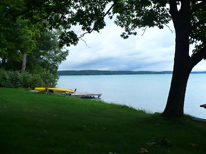 Sunshine yellow kayak waits patiently on verdant shores, ready for its next exploration of Elk Lake's crystal waters.